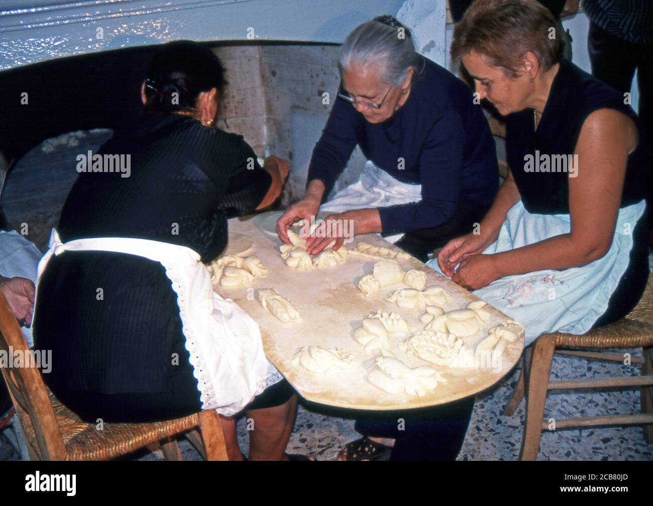 Women prepare traditional bread in Ollolai, Sardinia, Italy (scanned ...