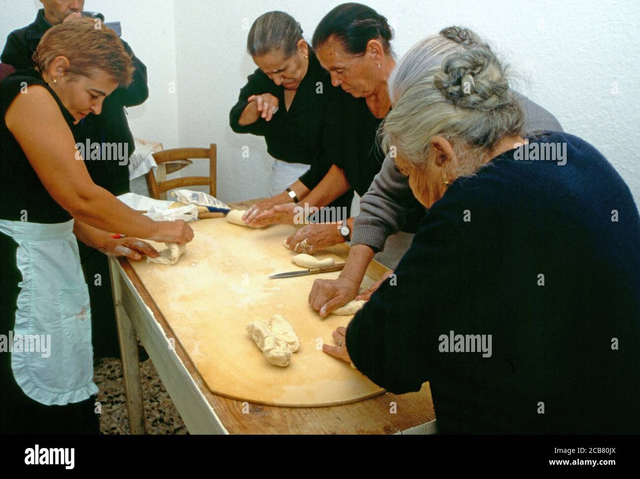 Women prepare traditional bread in Ollolai, Sardinia, Italy (scanned ...
