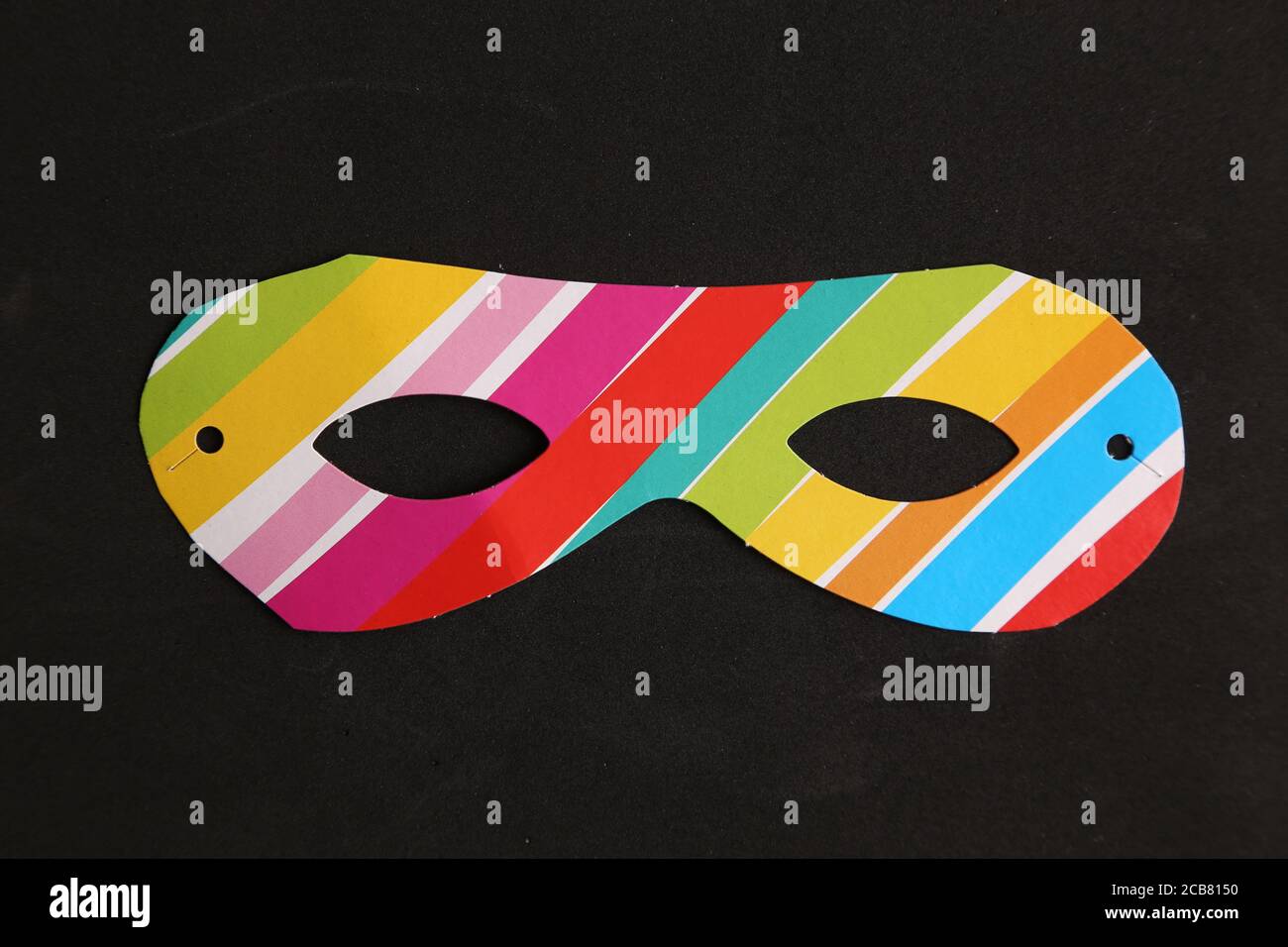 Colorful paper masquerade mask on a black surface Stock Photo - Alamy