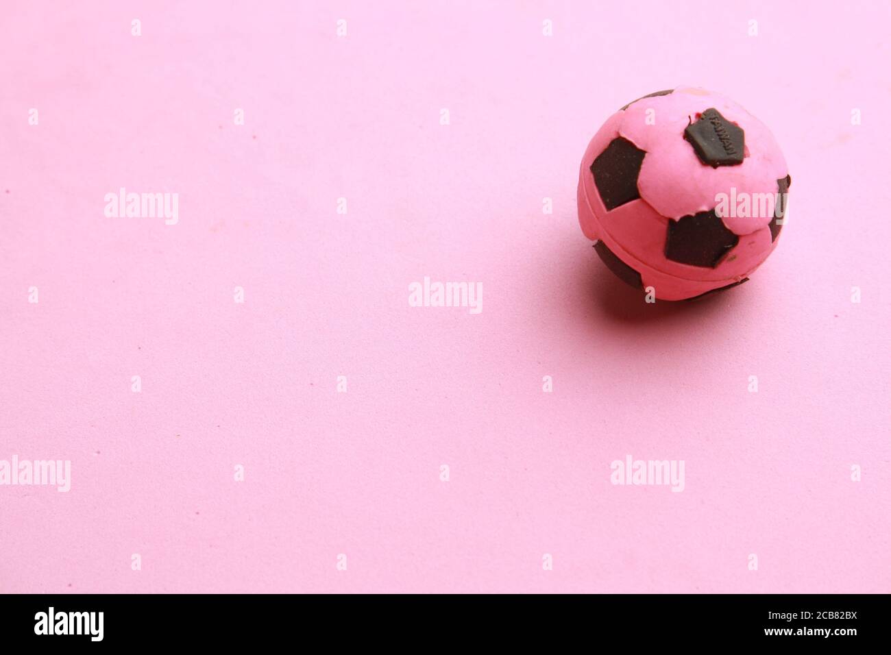 Small rubber ball isolated on a pink background Stock Photo - Alamy