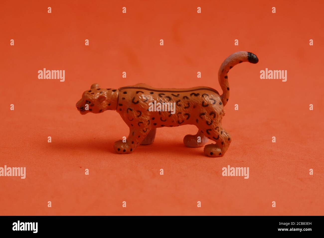 Plastic leopard toy on orange surface Stock Photo - Alamy