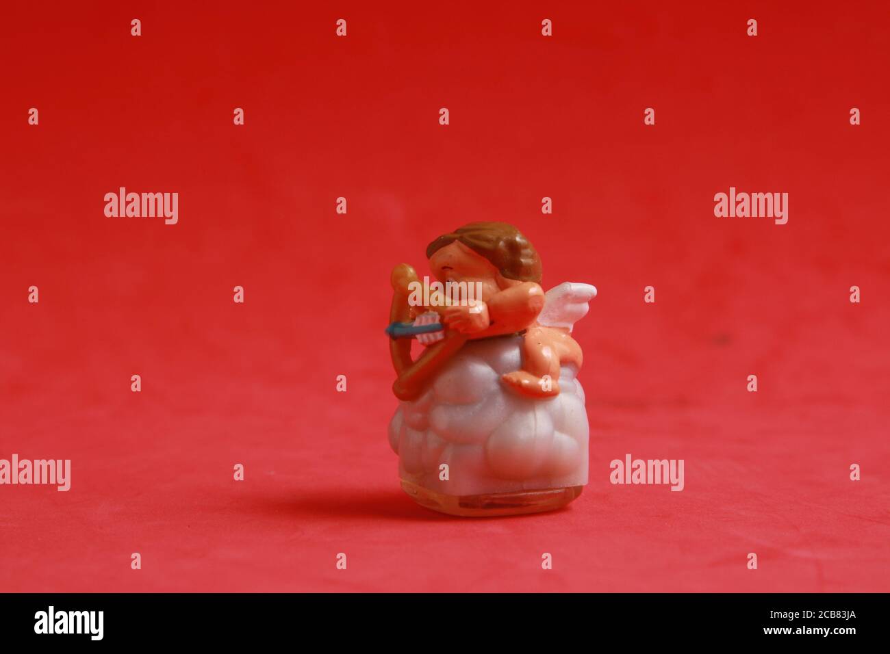 Small plastic angel toy isolated on a red background Stock Photo - Alamy