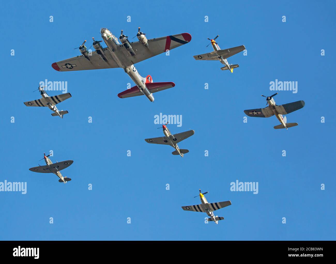 World War II aircraft fly in formation against a deep blue sky at the ...