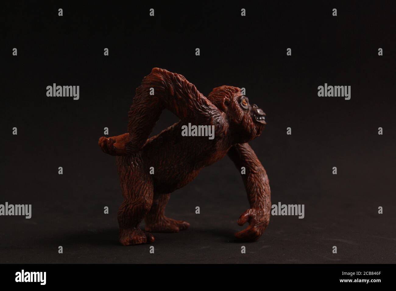 Orangutan shaped plastic toy in black background Stock Photo - Alamy