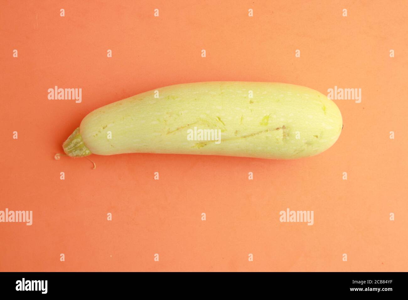 Fresh zucchini isolated on an orange background Stock Photo - Alamy