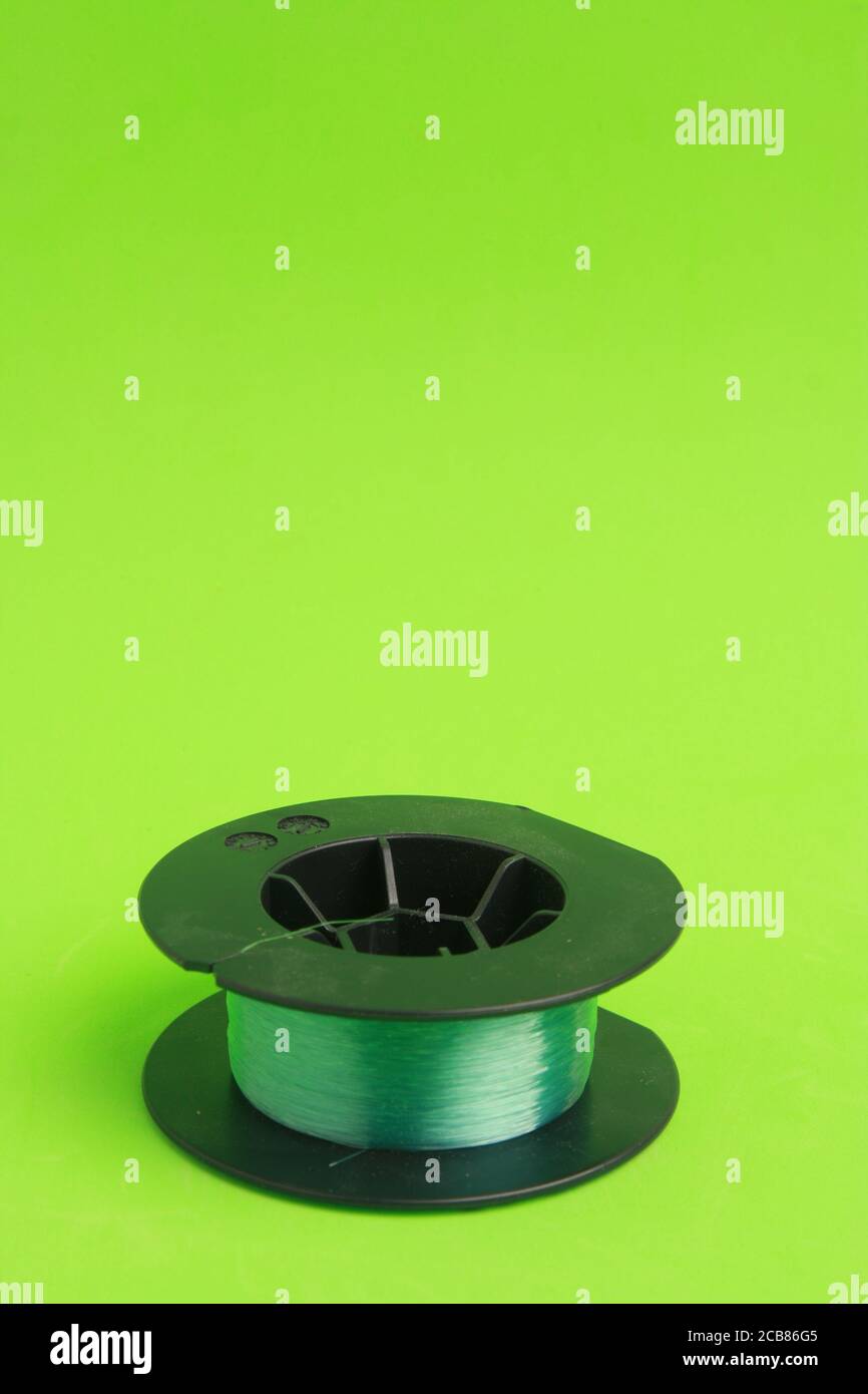 Vertical shot of a metal wire spool isolated on a green background ...
