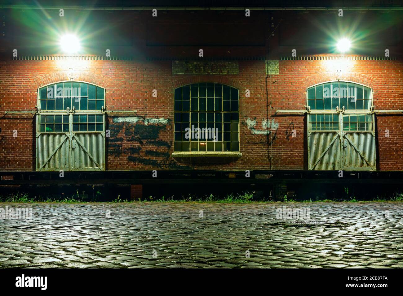 An old warehouse at night, gates of an old warehouse, loading ramps of ...