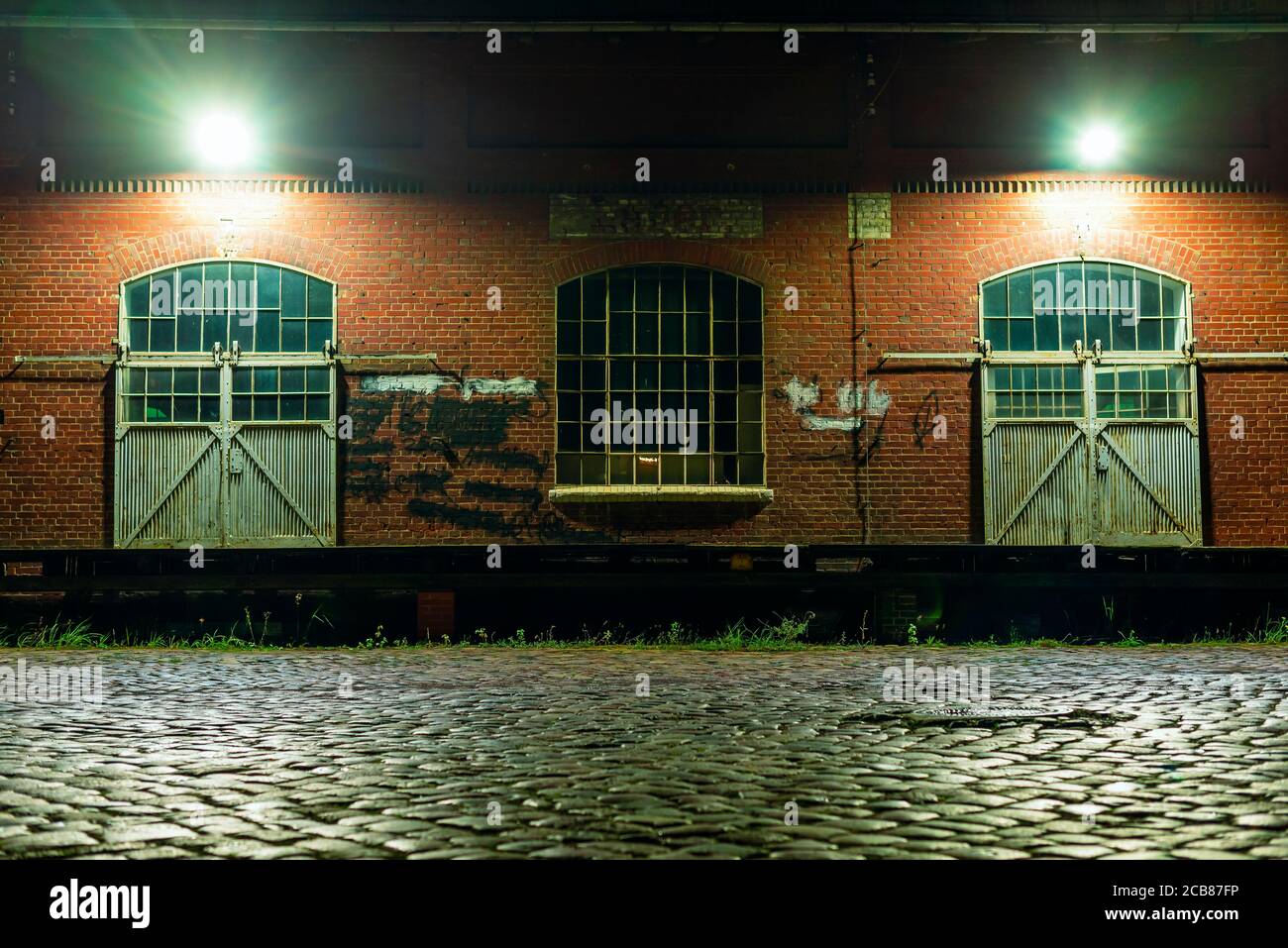 An old warehouse at night, gates of an old warehouse, loading ramps of ...