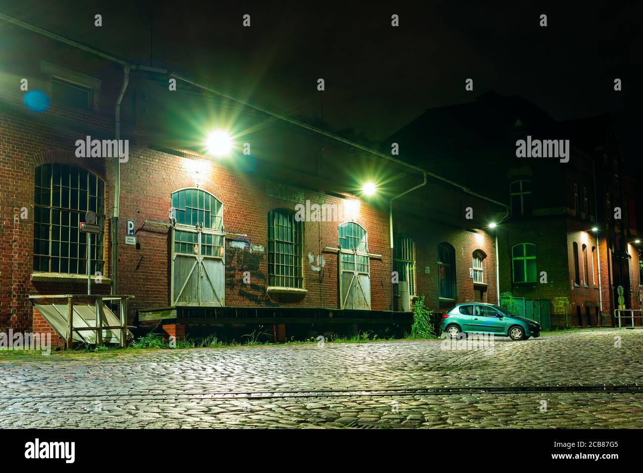 An old warehouse at night, gates of an old warehouse, loading ramps of ...
