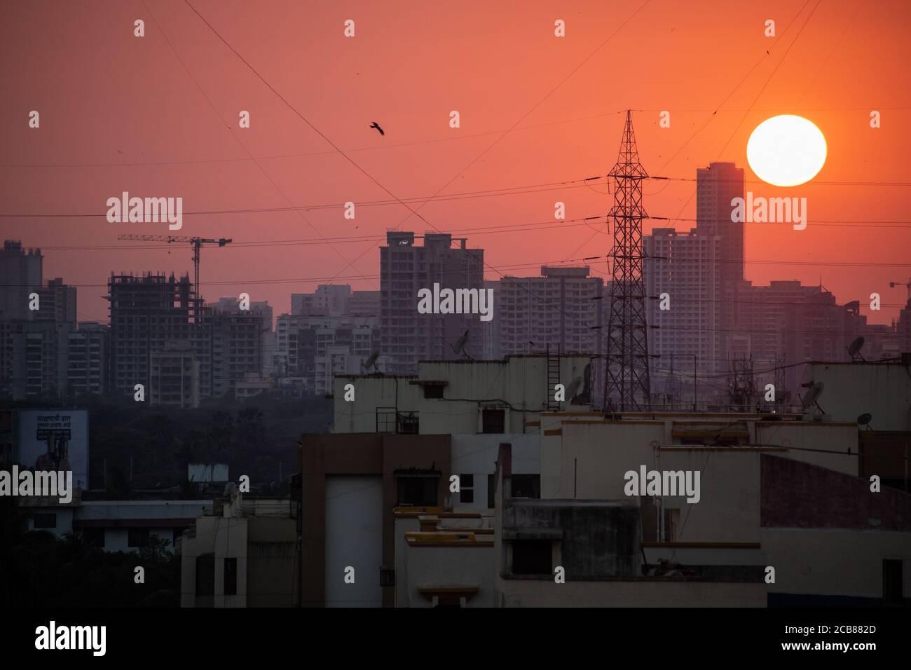 Mumbai, Maharashtra, India - March 2020: Sun setting behind an electric ...