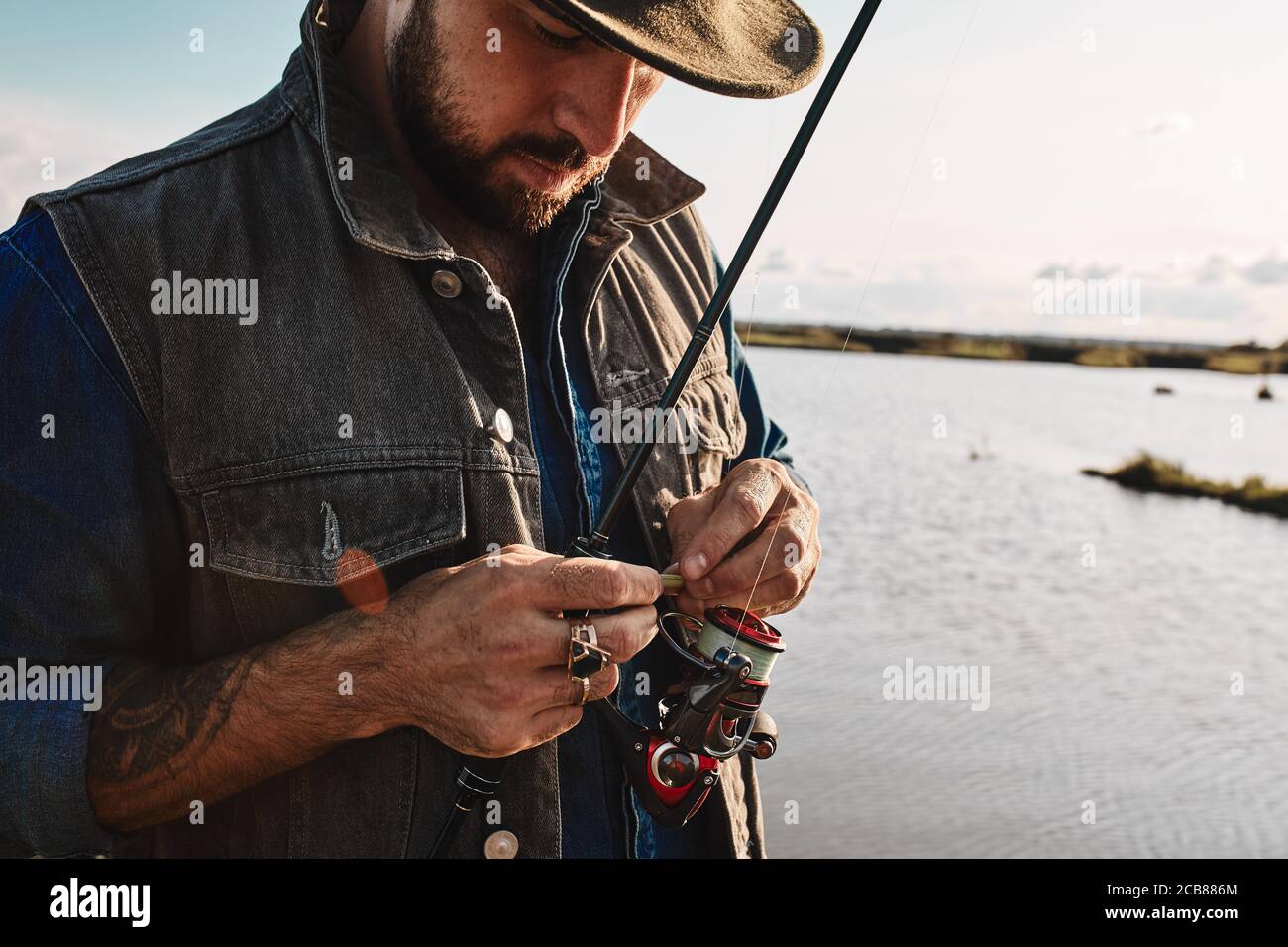 Father shows son how use fishing rod. Background blue lake Stock Photo ...