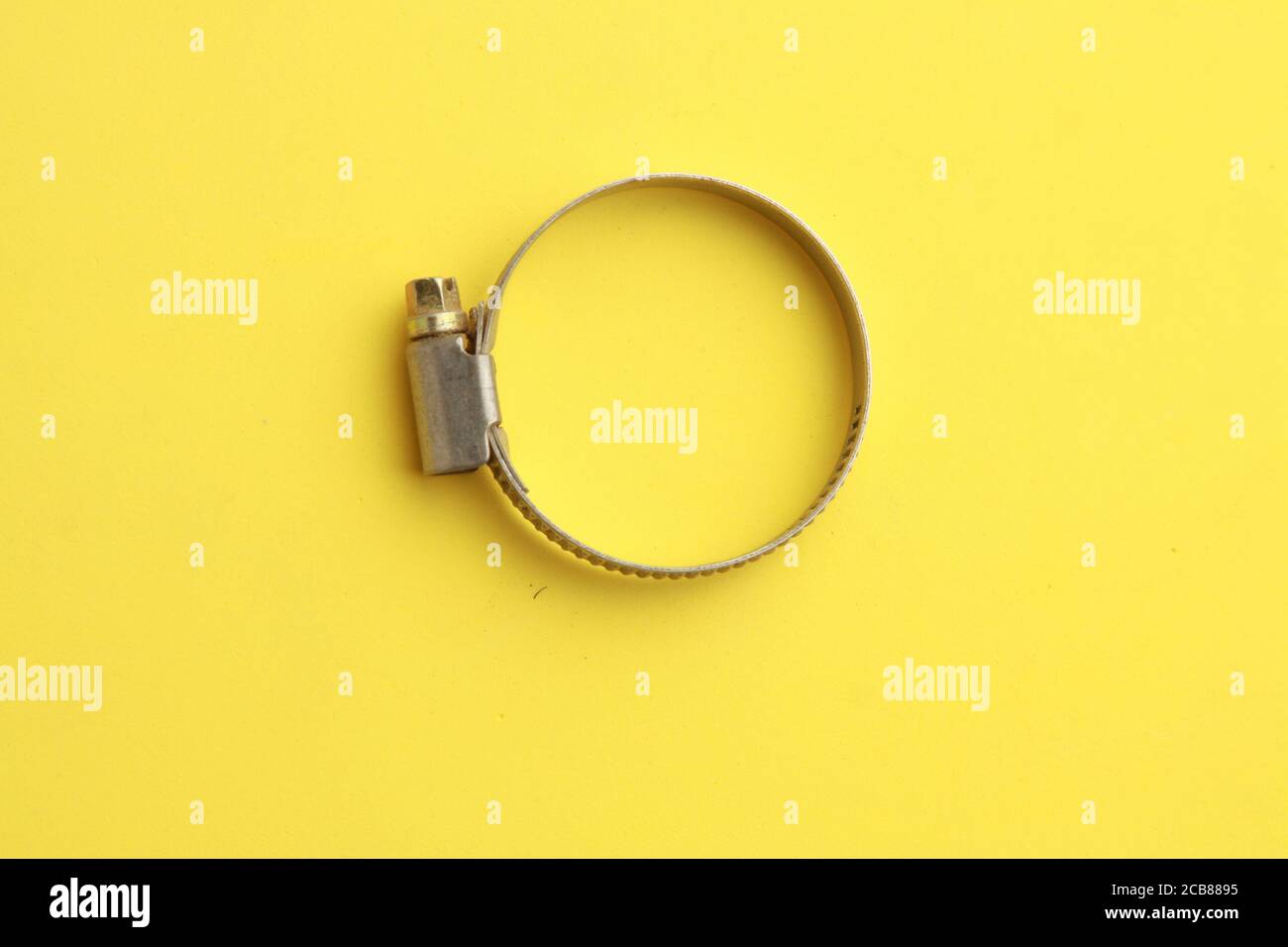 Top view of a metal plumber clamp on a bright yellow background Stock ...