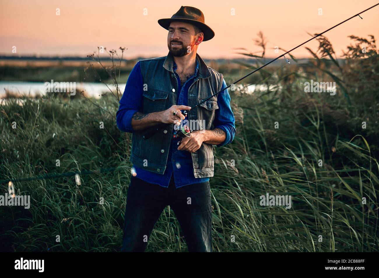 Father fish on pier. Sunset. Evening nibble is good Stock Photo - Alamy