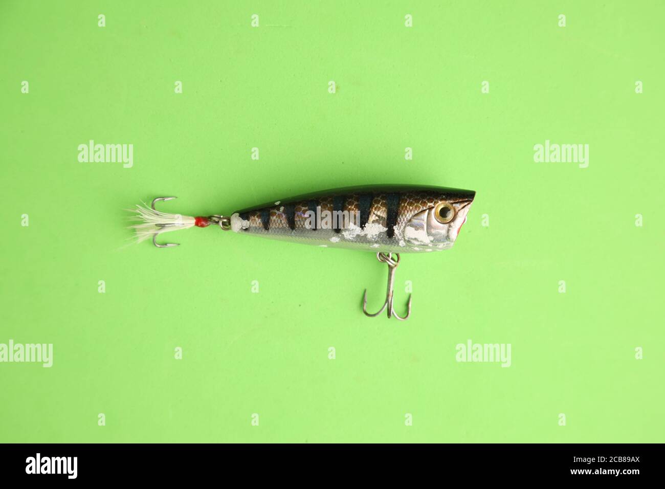 Fishing lure in the shape of fish on a green background Stock Photo - Alamy