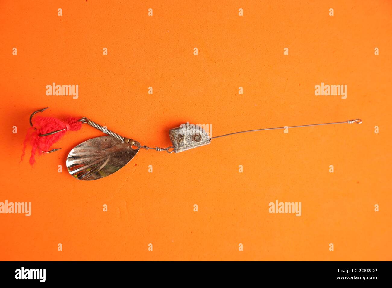 Top view closeup shot of a fishing tackle bait on an orange background ...