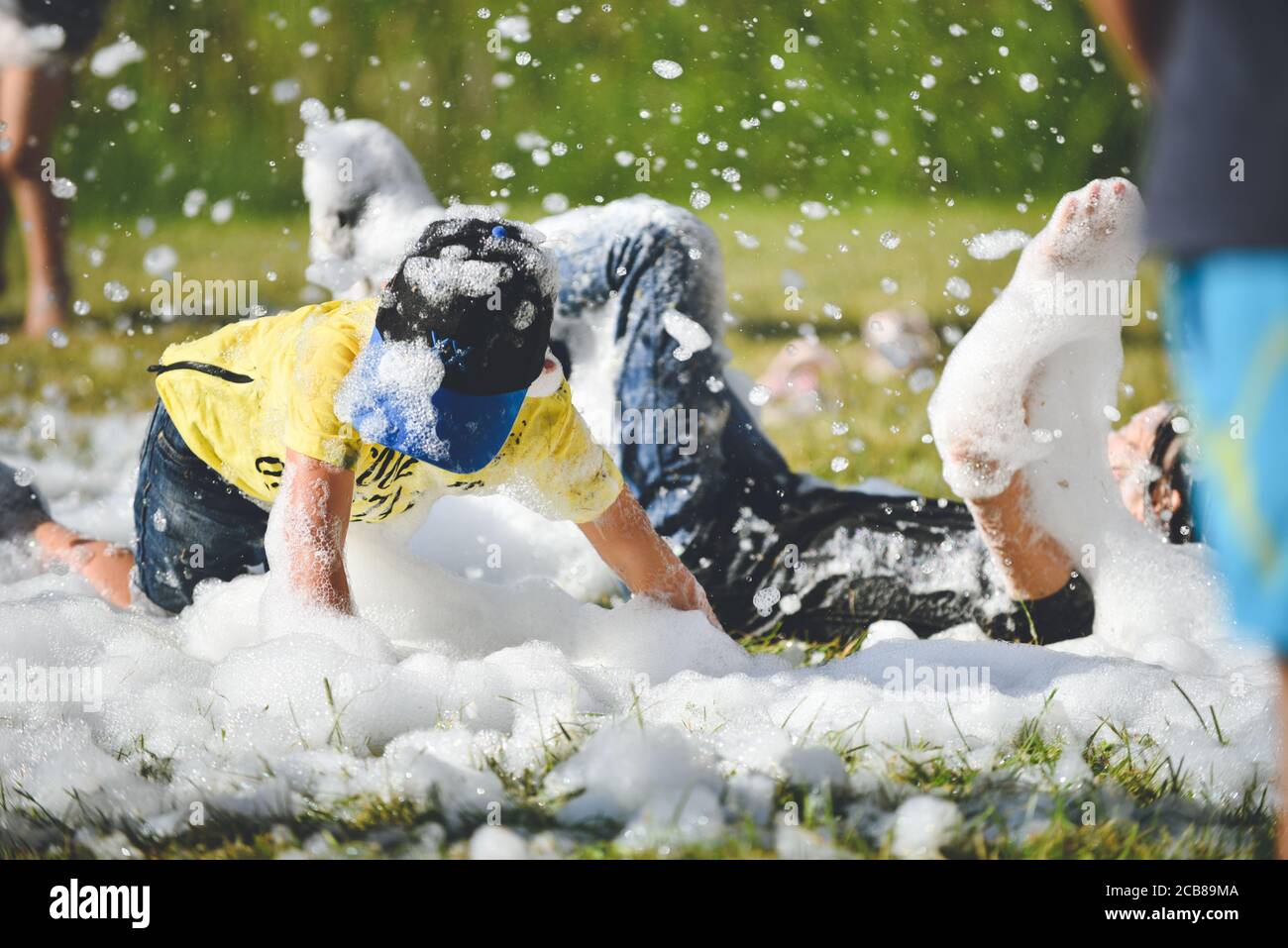 Young people in the foam. A foam party. Group of children having fun ...