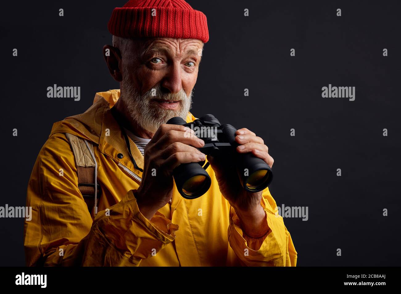 old hiker with tourist equipment looking at the camera, close up photo ...