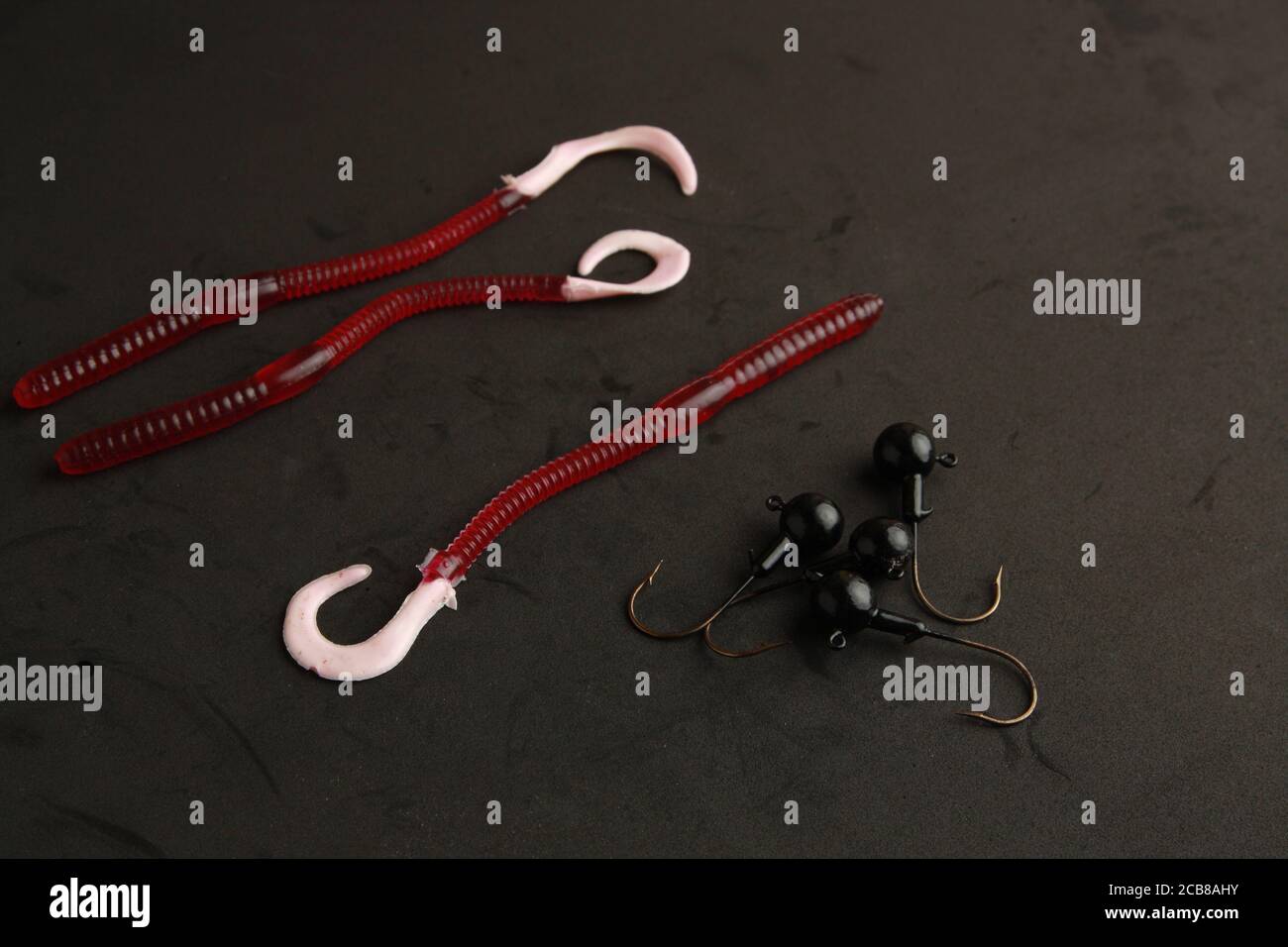 Closeup of colorful different fishing lures and hooks on a black ...