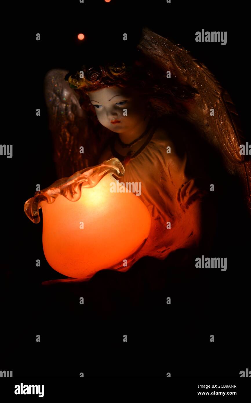 Close up of an angel bottom lit by an orange lamp Stock Photo - Alamy