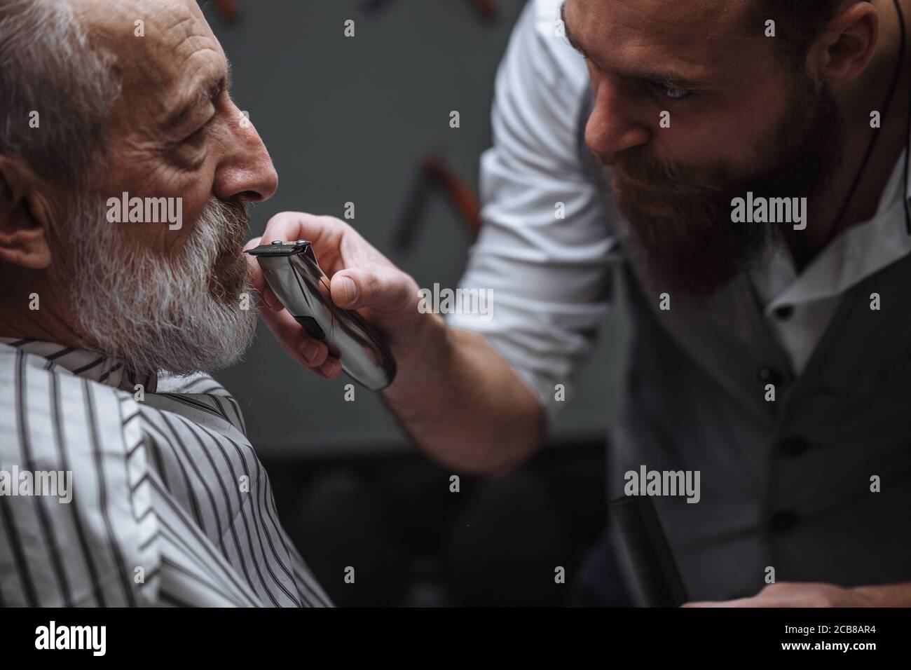 Good-looking bearded male Barber models beard for a handsome oldster at ...