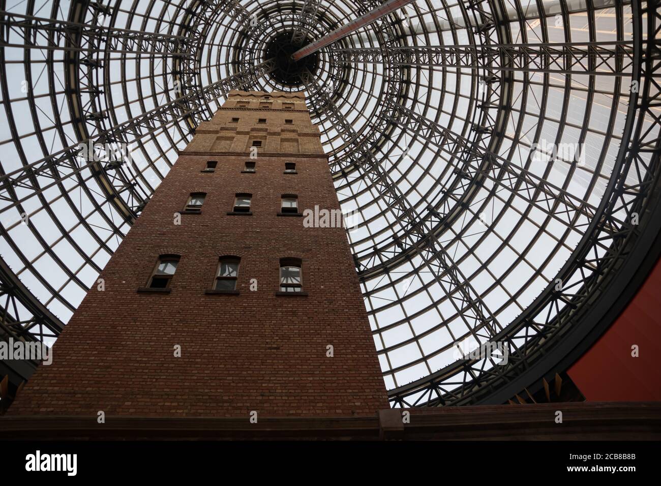 Brick building in interior of shopping mall and glass cupule background ...