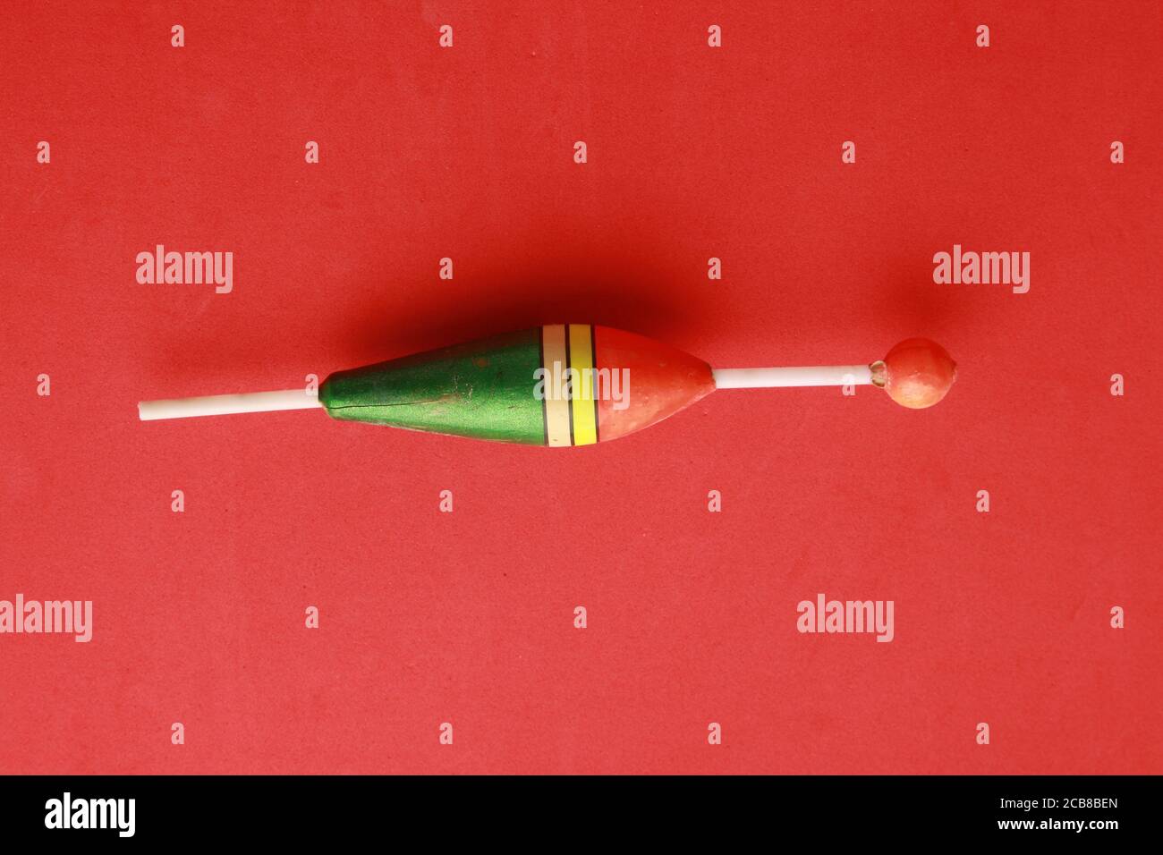 Top view of a colorful fishing rod bobber on a red background Stock ...