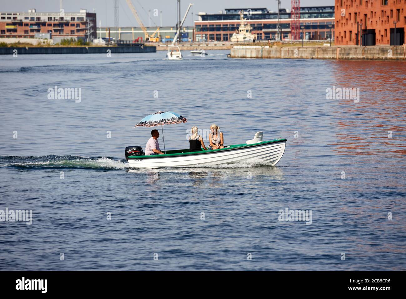 Three people in a small dinghy with an parasol; Copenhagen Harbour ...