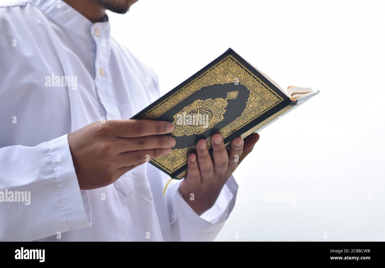 Holy Quran in hand with arabic calligraphy meaning of Al Quran Stock ...