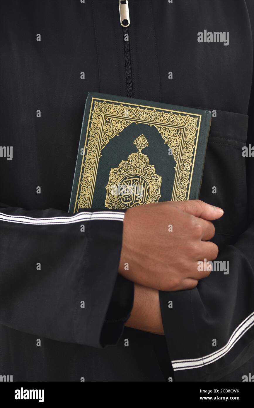 Holy Quran in hand with arabic calligraphy meaning of Al Quran Stock ...