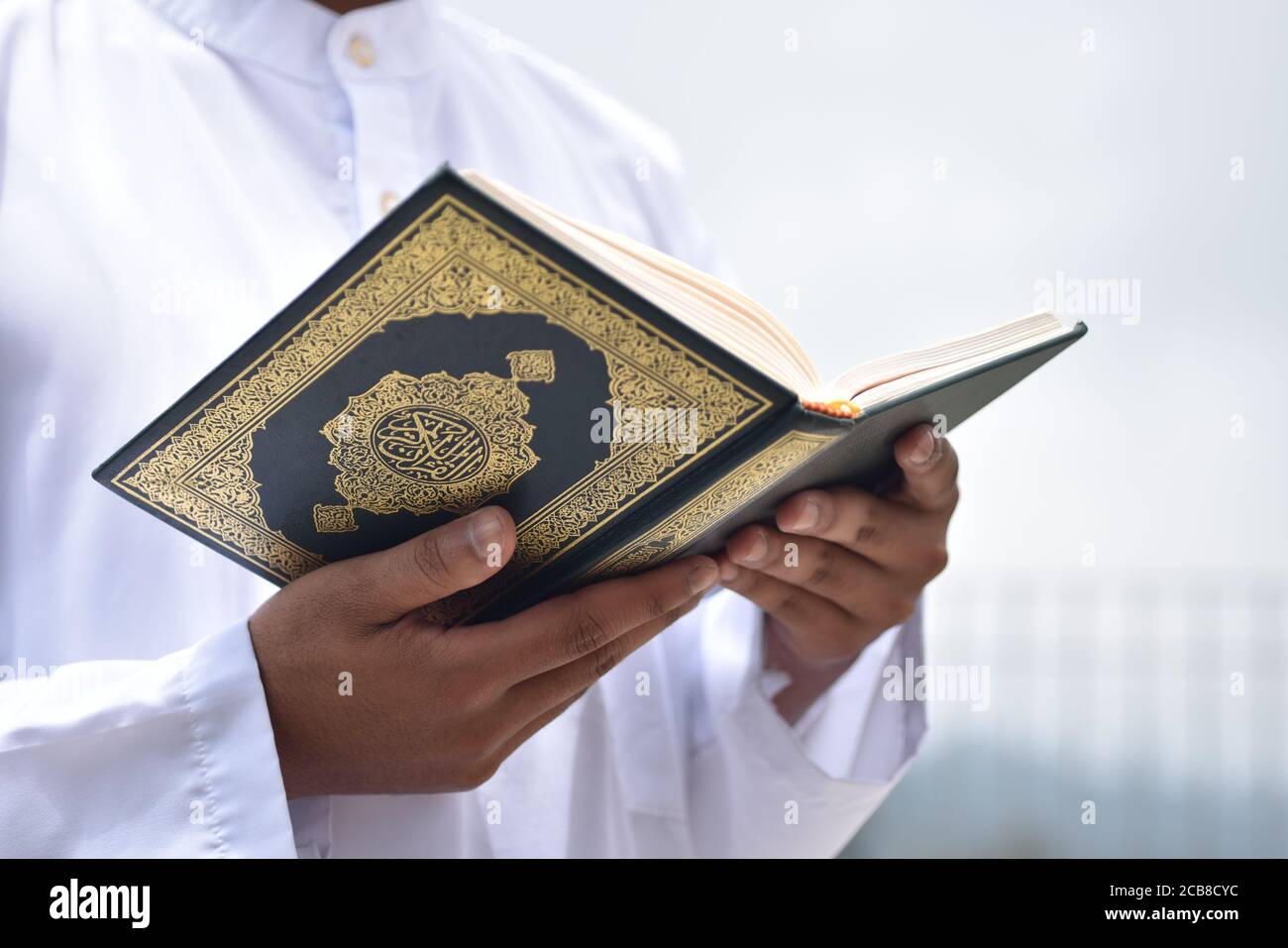 Holy Quran in hand with arabic calligraphy meaning of Al Quran Stock ...