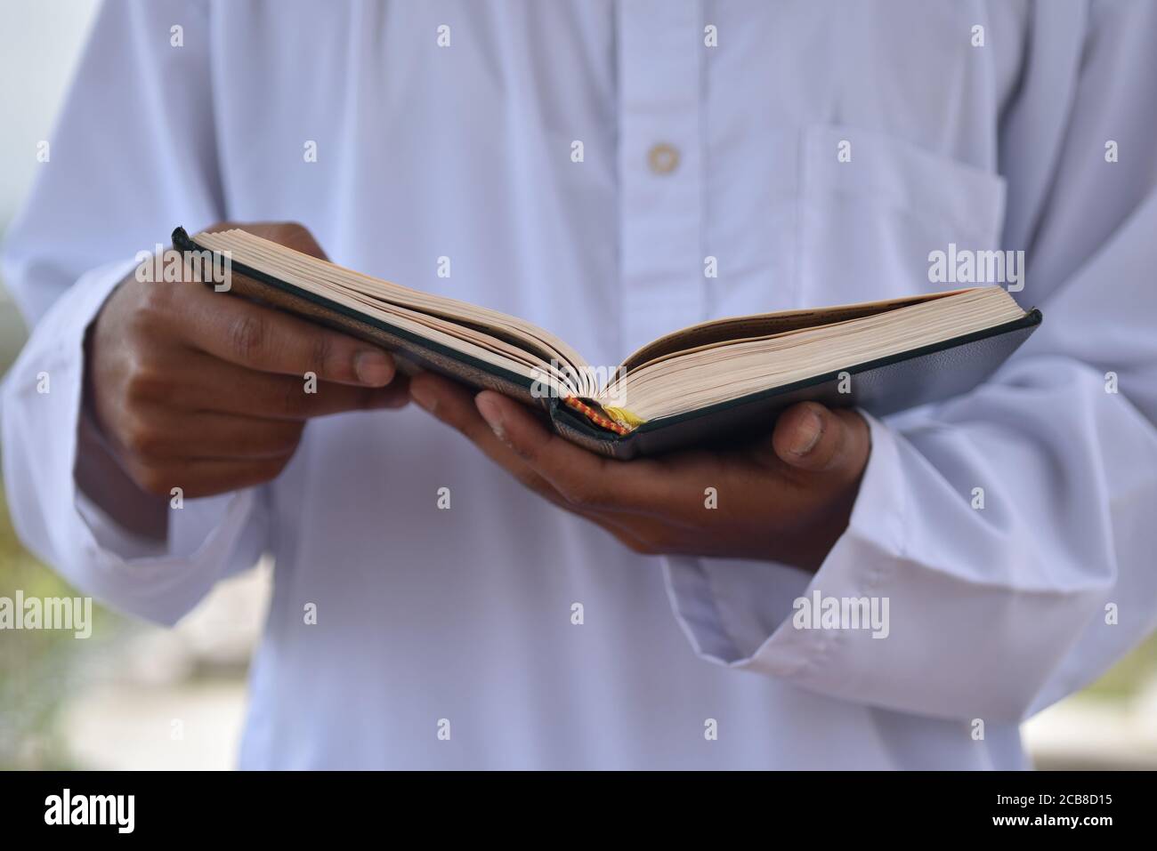 Holy Quran in hand with arabic calligraphy meaning of Al Quran Stock ...