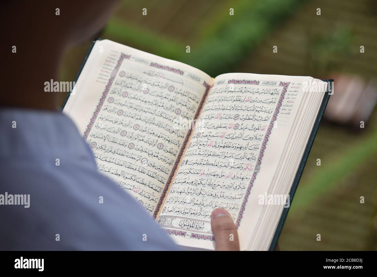 Holy Quran in hand with arabic calligraphy meaning of Al Quran Stock ...