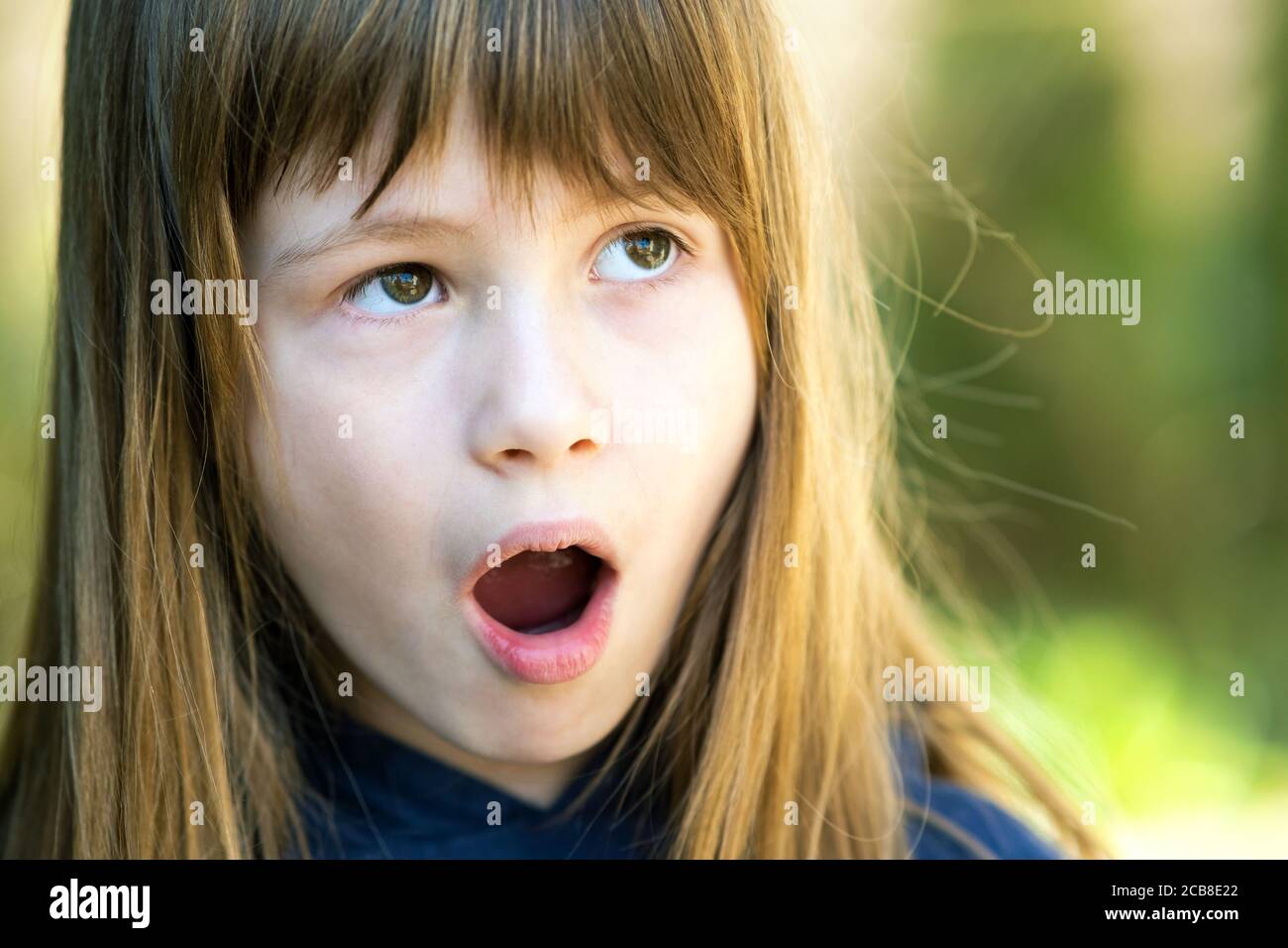 Portrait of surprised child girl outdoors in summer. Shocked female kid ...