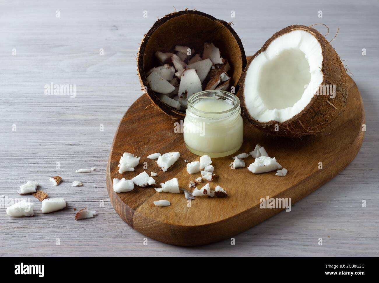 Coconut oil and fresh coconuts on the wooden table Stock Photo - Alamy