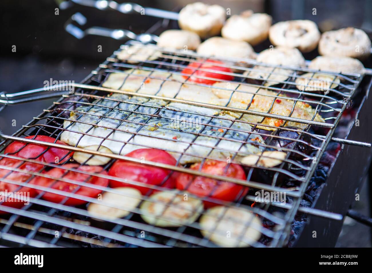 bbq concept fish on fire with mushroom and tomatoes Stock Photo - Alamy