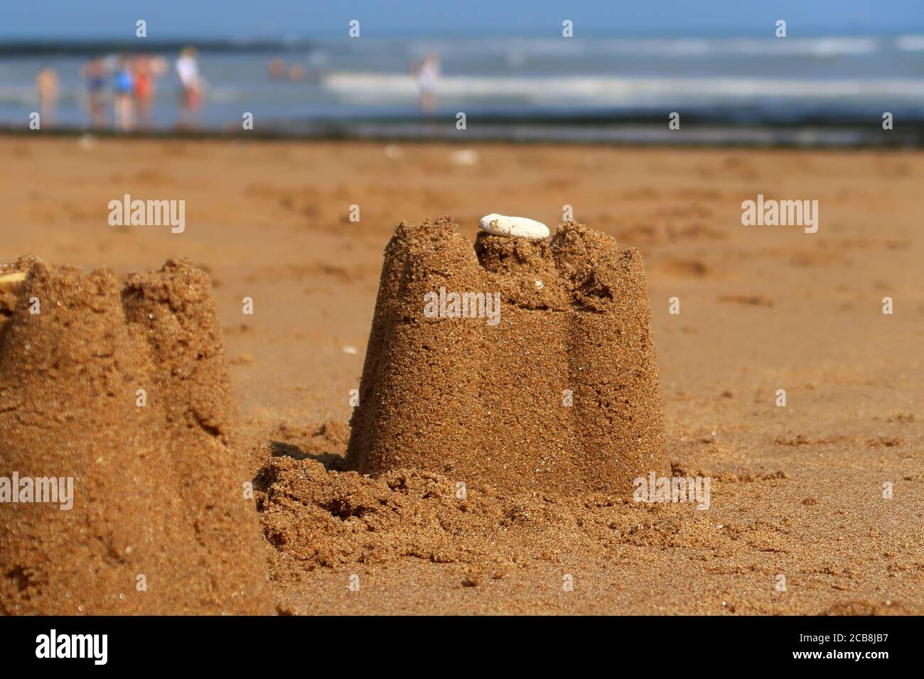 A still life scene at the beach with a sand castle to illustrate the ...