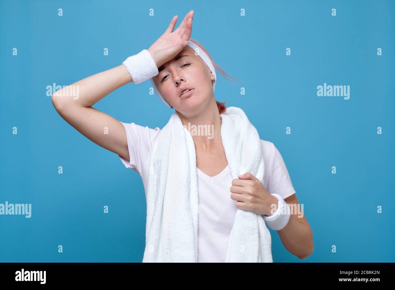Fitness young woman with her hand on head sweating Stock Photo - Alamy