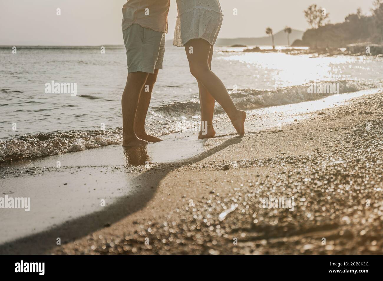 Legs on beach. Foot spa. A young loving couple hugging and kissing on ...