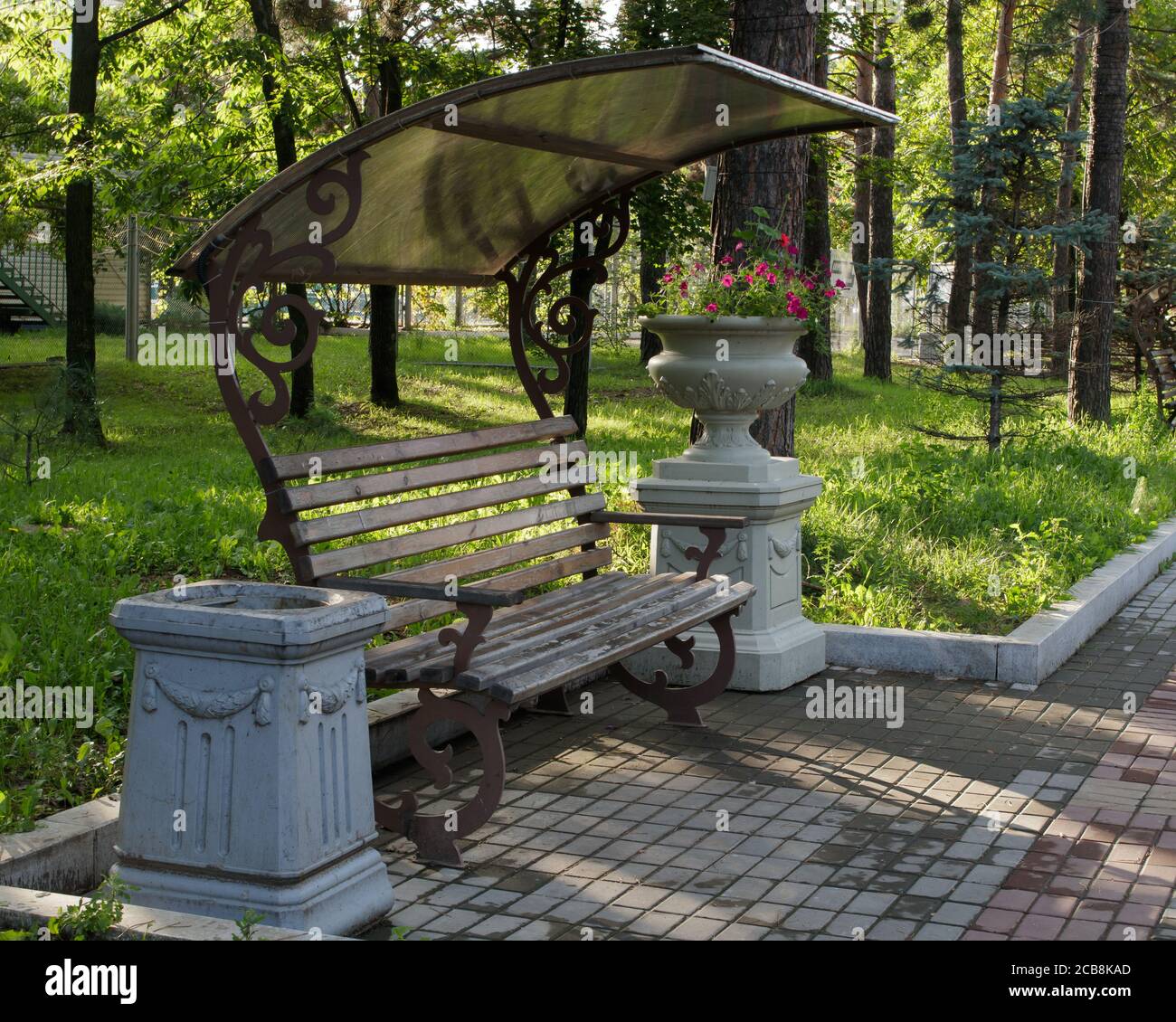 Wooden bench in a park in front of trees hi-res stock photography and ...
