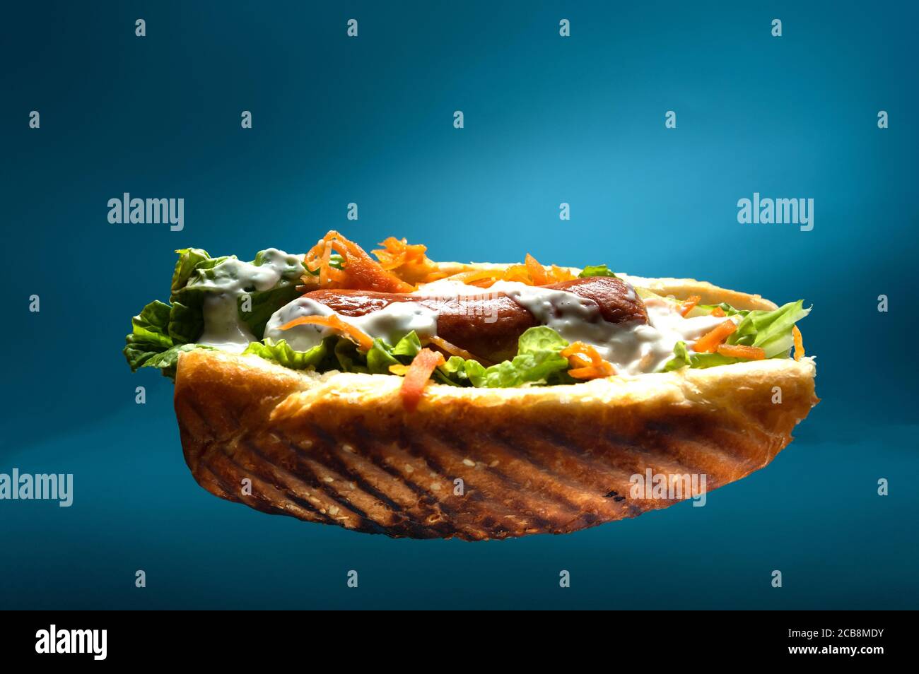 Grilled hot dog. Hot dog with sausage and salad. Front view Stock Photo ...