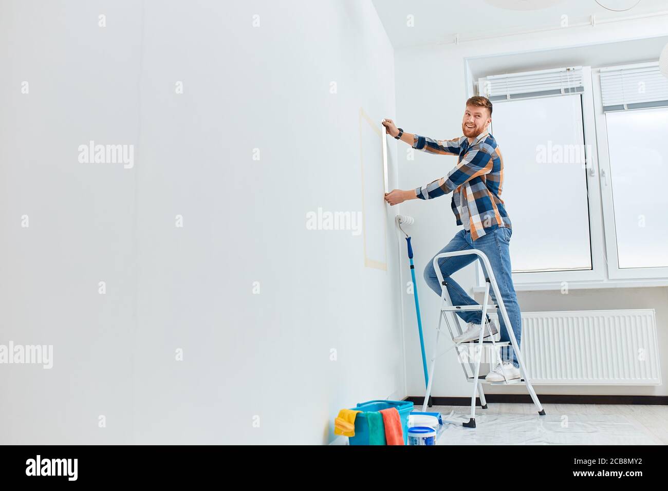 Male architect or interio designer measuring wall with flexible ruler ...