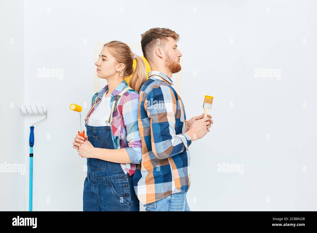 Portrait of confident young diverse painters, standing with paint tools ...
