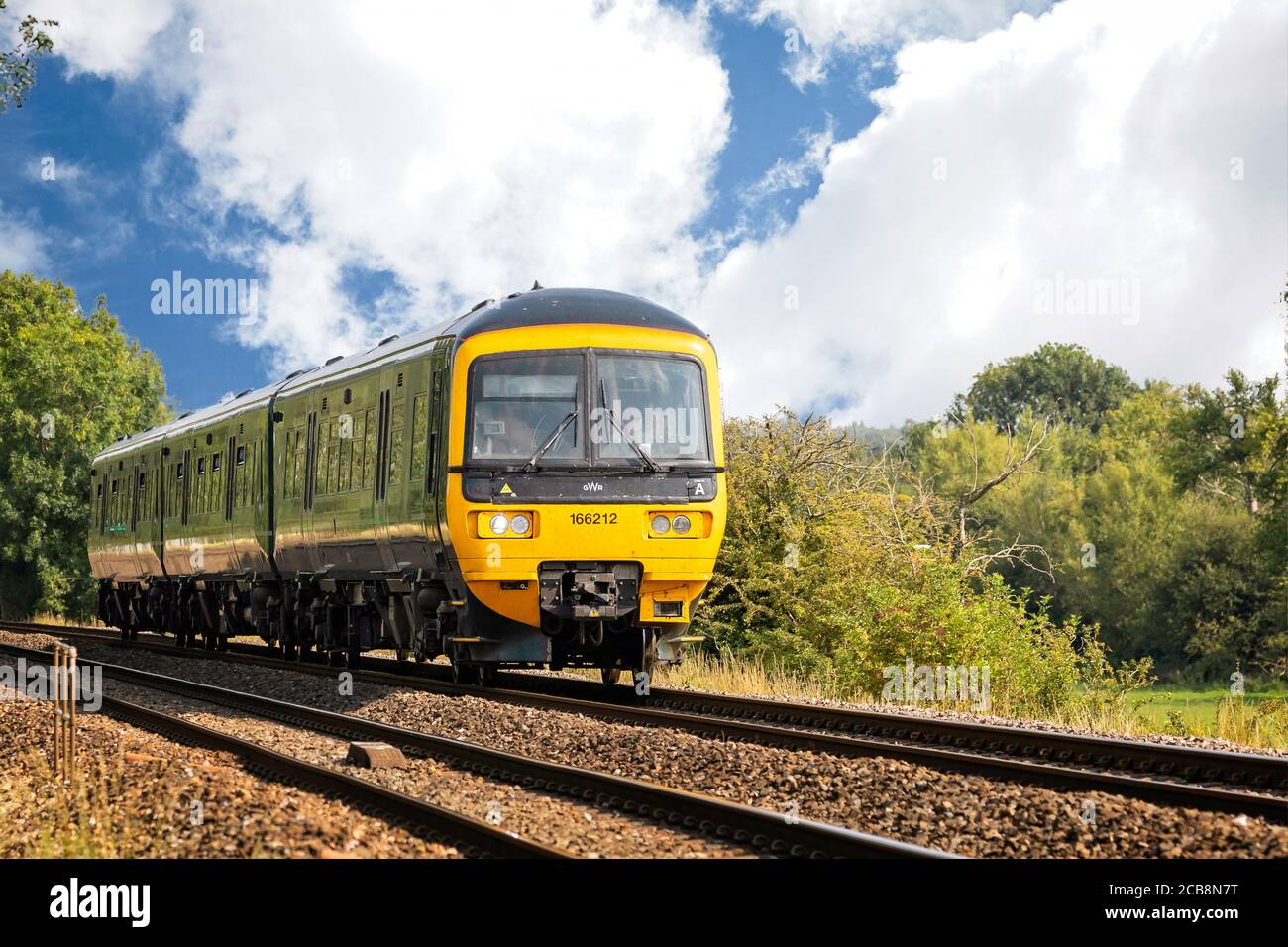 Commuter train approaching country pedestrian railway track crossing ...