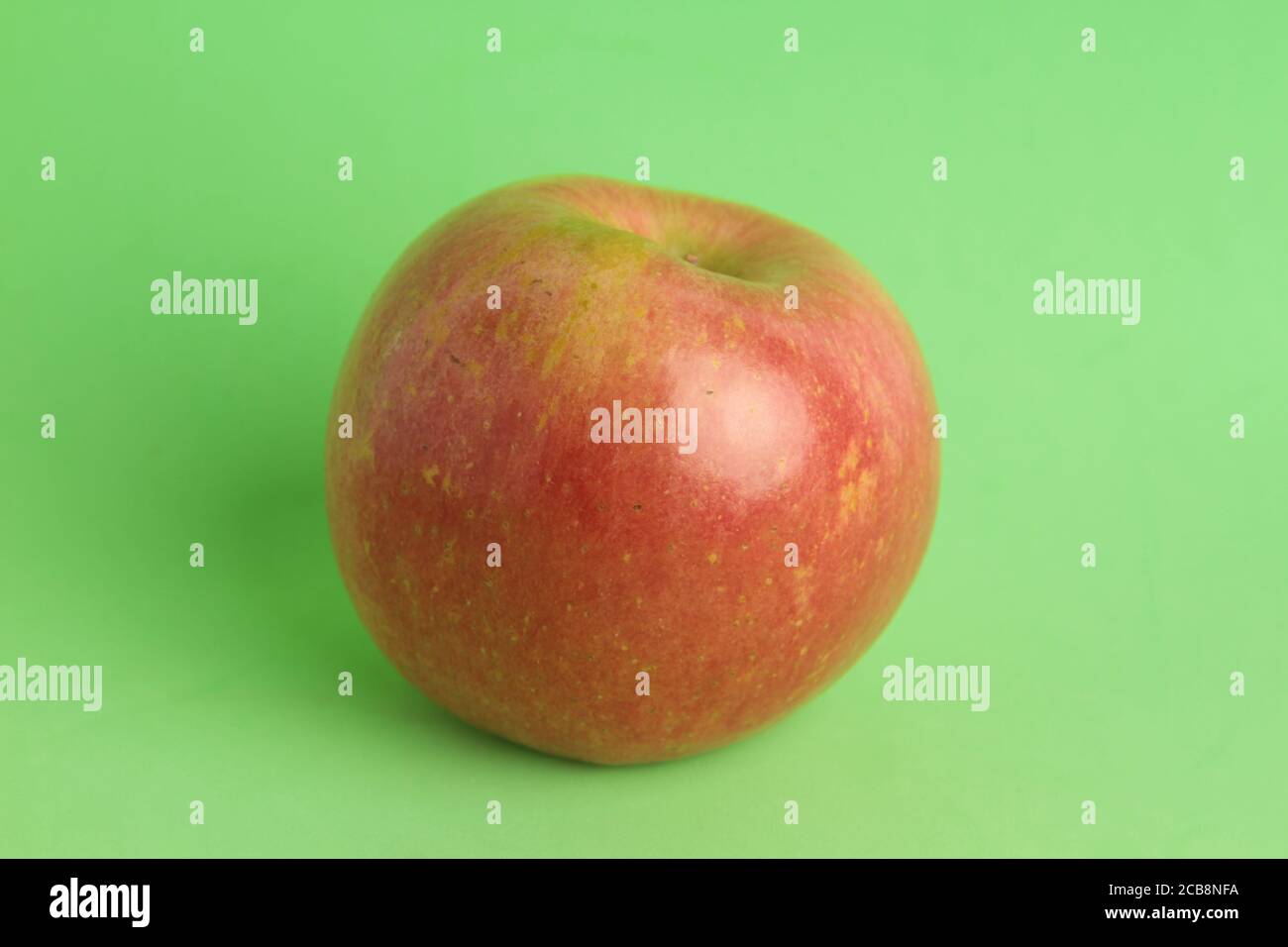 Red apple with a green background Stock Photo - Alamy