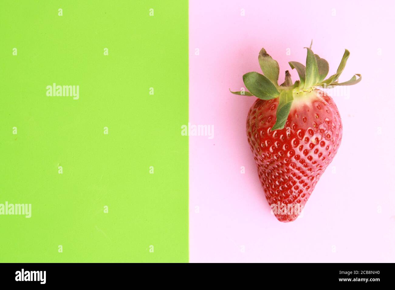 Top view of a strawberry under the lights on a colorful surface Stock ...