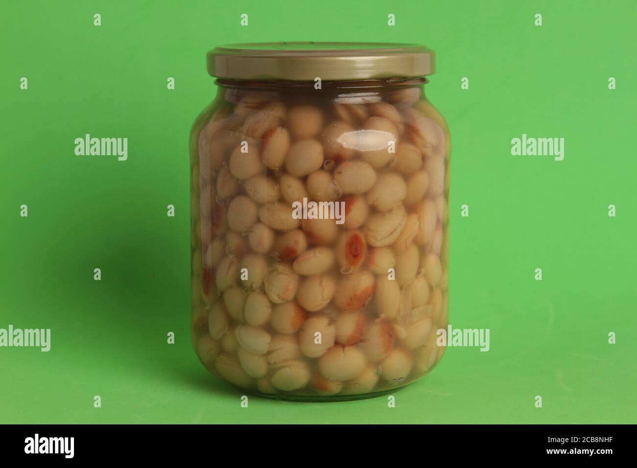 Jar of canned dried beans on green background Stock Photo - Alamy