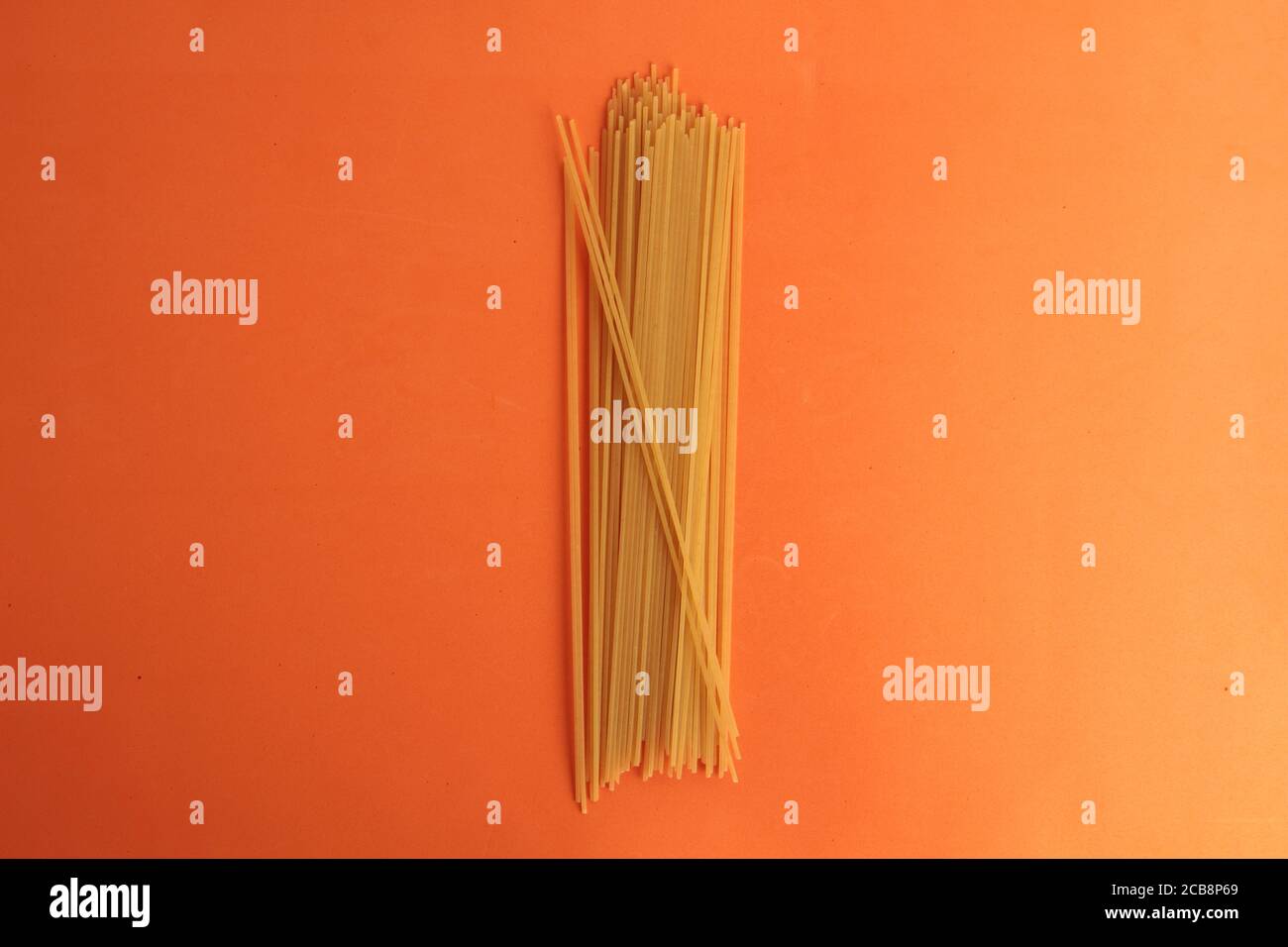 Top view of a pile of raw spaghetti on an orange surface Stock Photo ...