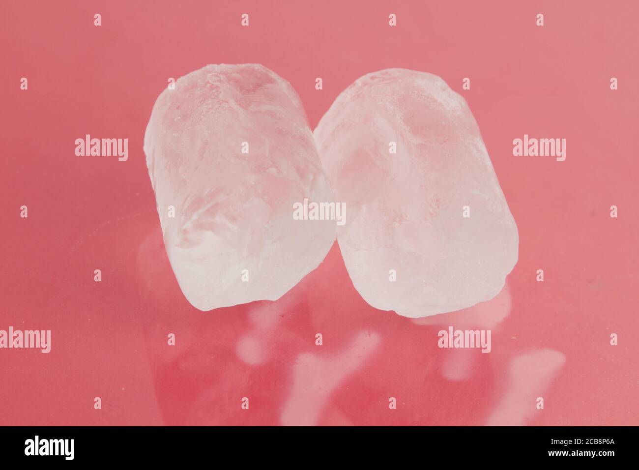 High angle shot of two pieces of ice isolated on a pink surface Stock ...