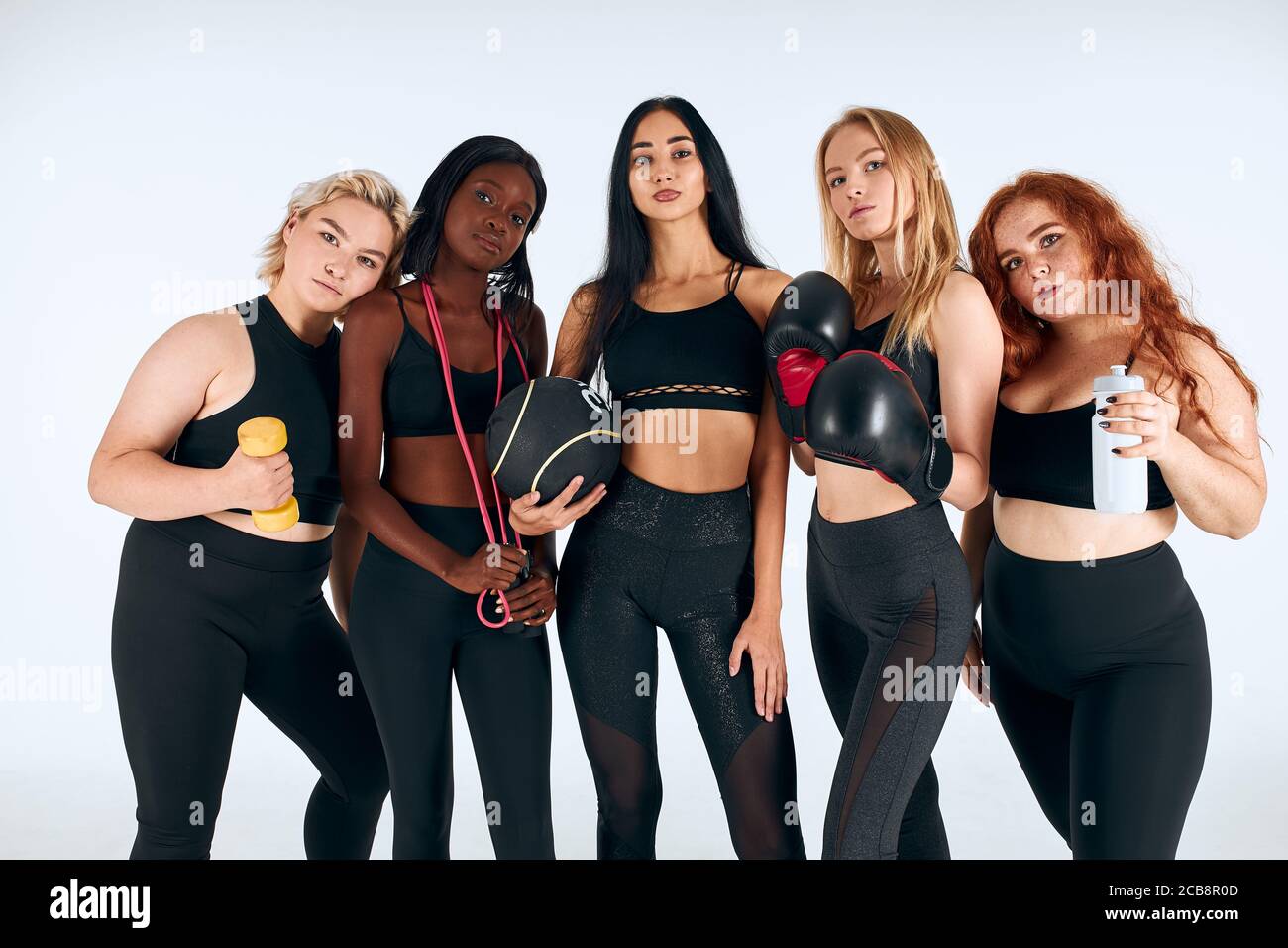 Sportive girls in sport wearing stand together with boxing gloves ...
