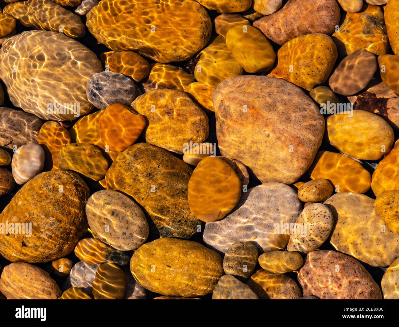 Flowing lake water over beach stones along Lake Huron, Michigan, USA ...